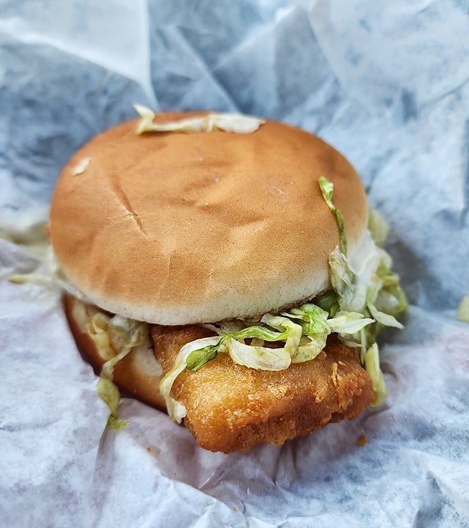 Golden fish sandwich perfection that proves seafood and fast food can absolutely be soulmates.