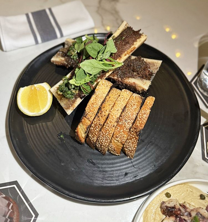 Decadence on a plate &ndash; velvety marrow waiting to be spread on toast, with fresh greens for balance.