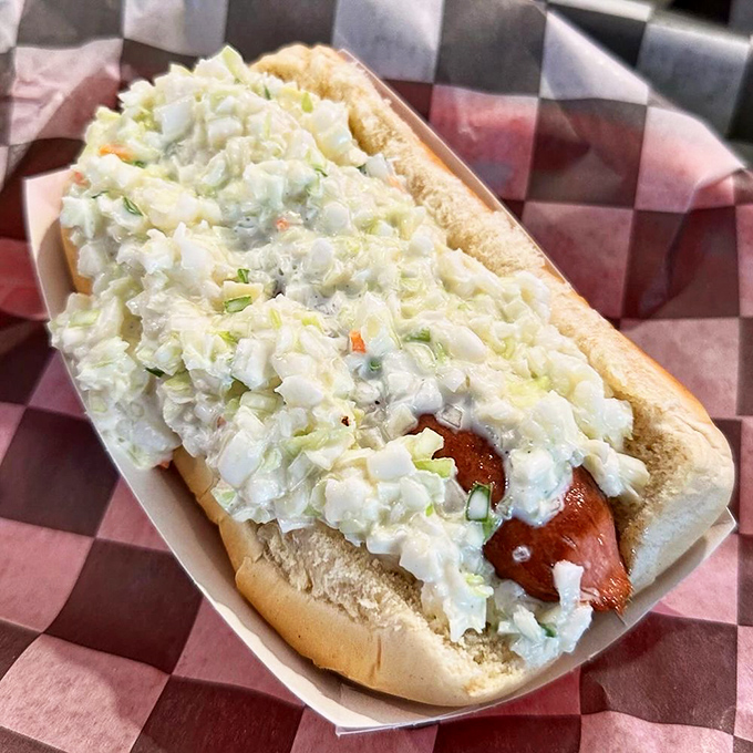 A perfectly grilled hot dog absolutely smothered under a mountain of creamy, tangy coleslaw &ndash; worth every extra napkin you'll need.