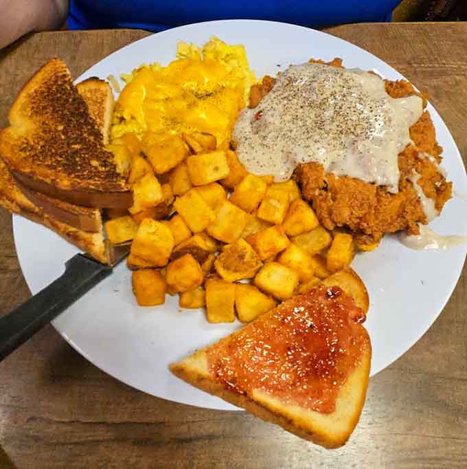 The chicken fried steak breakfast plate is basically a dare, challenging you to finish this mountain of crispy, gravy-covered goodness with all the fixings.