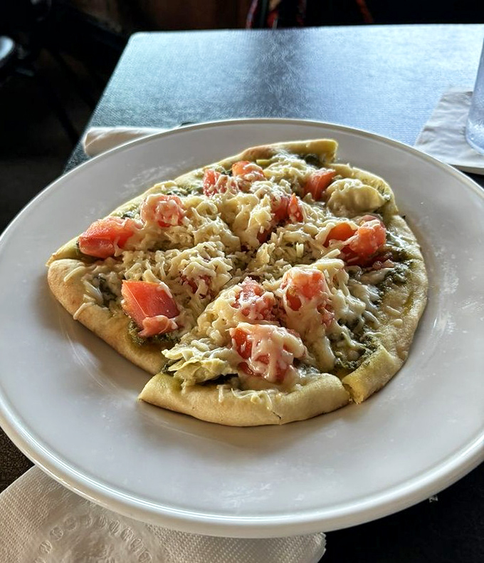 Scrambled eggs and fresh vegetables crown this flatbread like edible confetti celebrating your excellent life choices today.