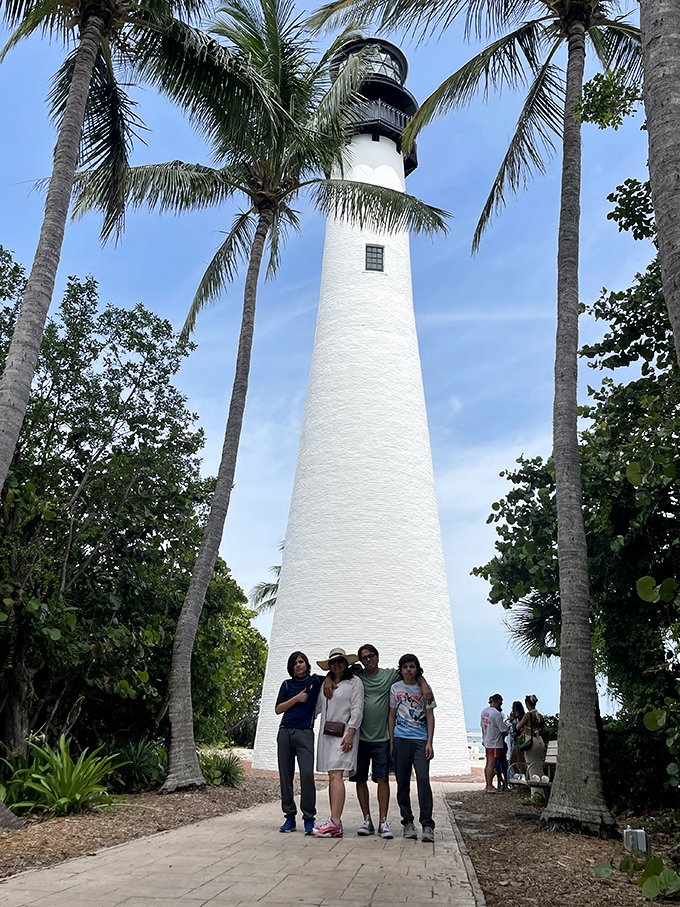 Families gather at the lighthouse base, their expressions shifting from "do we really climb all those stairs?" to "wow, that view was worth every step!"