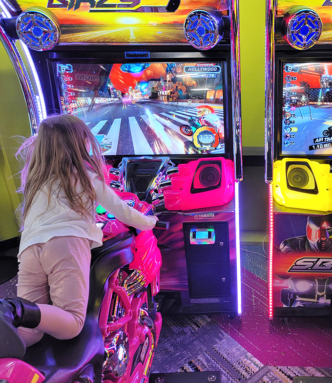 A young racer leans into the curve on a neon motorcycle game, proving video game driving skills develop long before actual road readiness.