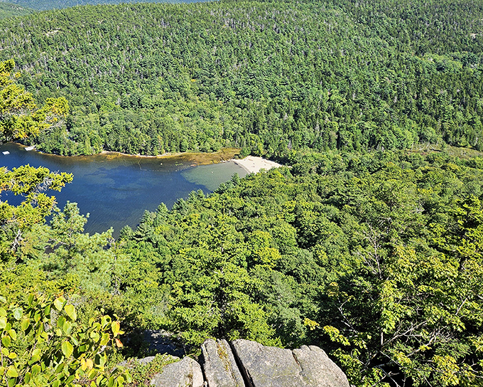 Another stunning vista of Echo Lake from above, showcasing the perfect crescent beach embraced by dense forest.