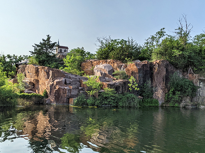 The quarry pond reflects the surrounding cliffs like a mirror specially designed for geological narcissism &ndash; impossibly clear and perfectly still.