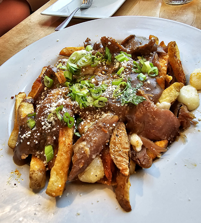This isn't just poutine &ndash; it's a religious experience disguised as an appetizer, with duck confit elevating the humble fry to gourmet status.