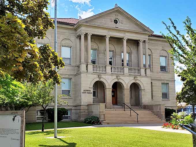 Alpena's impressive City Hall showcases classic stone architecture with columns and formal steps leading to its grand entrance.