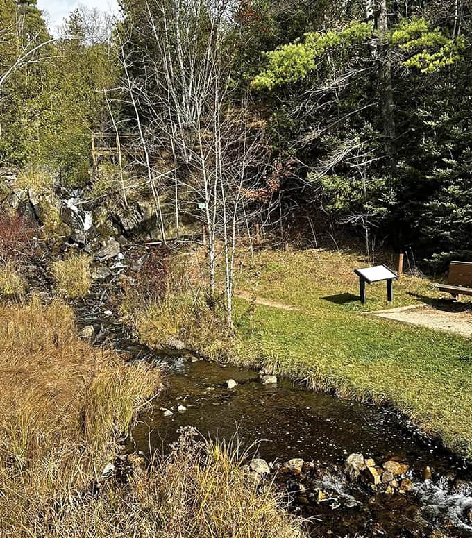 The waterfall creates a perfect sheet of water that looks like liquid glass frozen in motion against ancient stone.