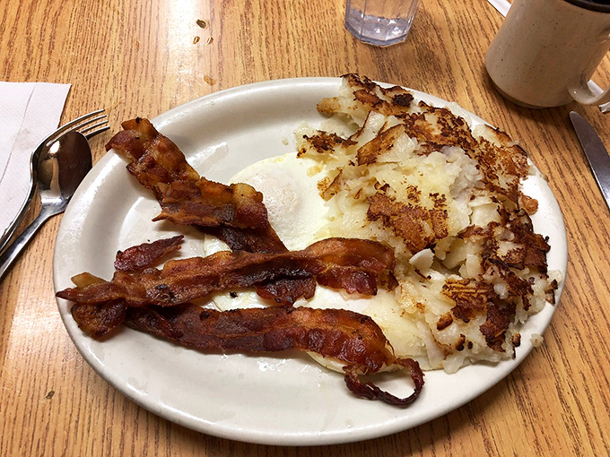 Crispy bacon and perfectly cooked eggs alongside hash browns with that magical crisp-outside, tender-inside texture that's the mark of a seasoned grill.