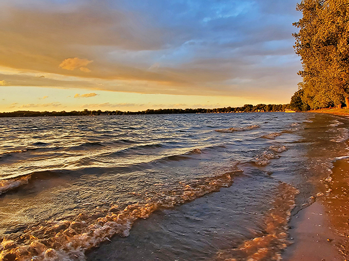 Golden hour transforms Wamplers Lake into a shimmering mirror, where beach-goers linger to catch the day's final rays.