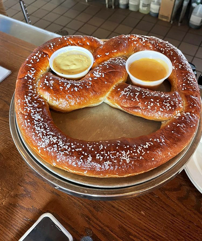 The legendary pretzel arrives like a doughy monument to German tradition, glistening with salt and served with house-made beer cheese and mustard.