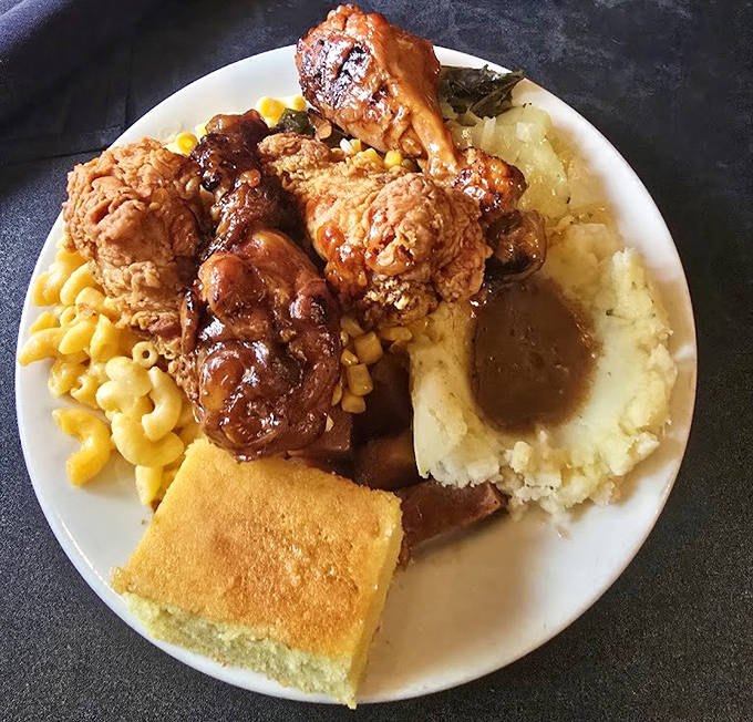 A plate that tells a story &ndash; smothered chicken, mac and cheese, and cornbread creating the comfort food trifecta of your dreams.