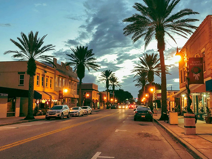 Flagler Avenue at dusk transforms into a tropical wonderland, where palm trees stand sentinel over evening strollers.