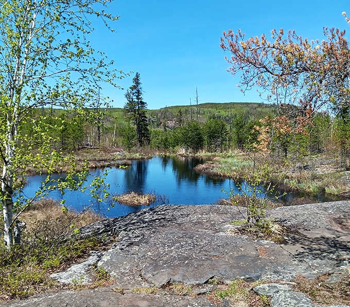 Crystal clear waters reflect the surrounding wilderness, creating perfect mirror images that double the beauty of this hidden gem.