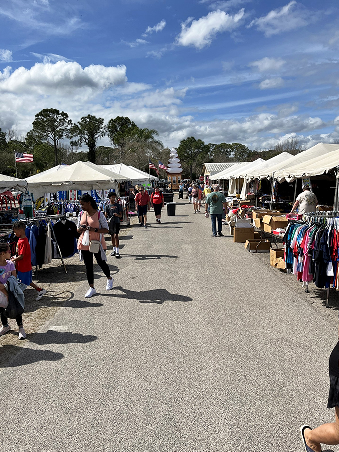 Weekend warriors unite! Shoppers navigate this outdoor section under Florida's blue skies, hunting for treasures among the white tents.
