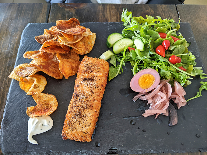 Crispy-skinned salmon, house-made potato chips, and a garden-fresh salad showcase the kitchen's commitment to simple, flawless execution.