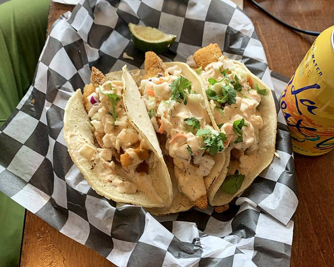 Walleye tacos transform Midwestern fish into a handheld delight, with creamy slaw and fresh herbs adding bright counterpoints to the crispy fish.
