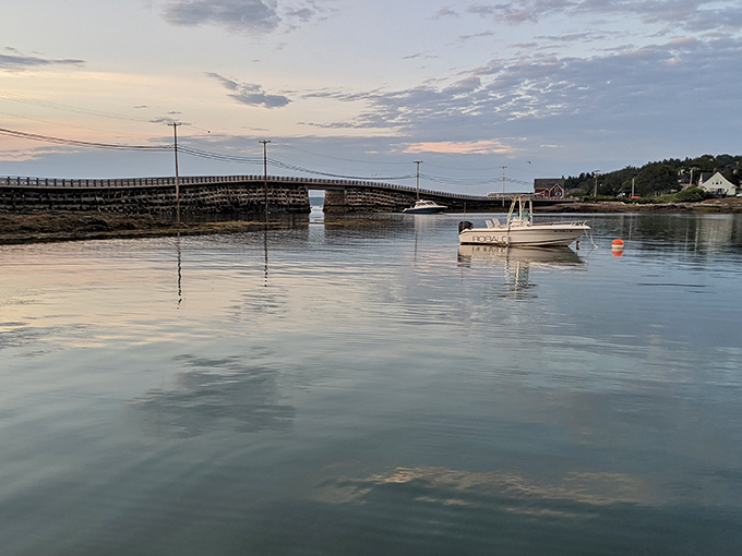 Sunset paints the bridge in golden hues, transforming granite into a warm welcome between islands.