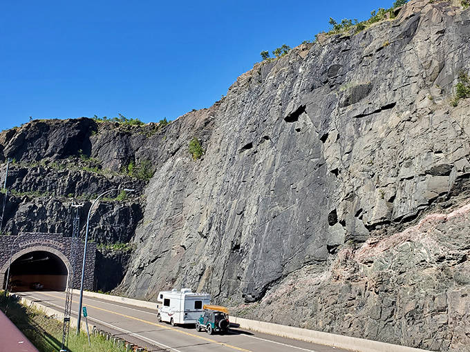 A camper van approaches the tunnel entrance, about to exchange the open sky for a brief journey through the heart of Minnesota's ancient bedrock.