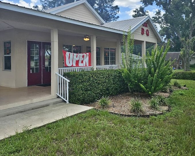 C & K Smokehouse's clean white building with neat landscaping shows BBQ is alive and well. The red door and "OPEN" banner welcome hungry travelers.