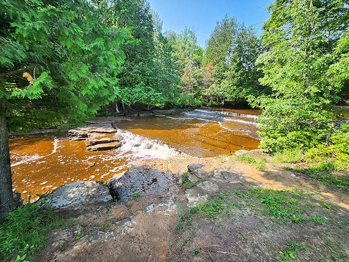 The cascading water reveals beautiful rock formations that tell stories millions of years old in shades of red and orange.