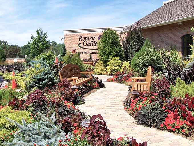 Rotary Gardens' entrance welcomes visitors with a riot of colorful blooms flanking a winding brick pathway that promises botanical discoveries.