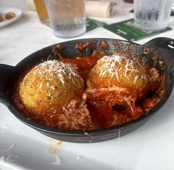These aren't just any arancini &ndash; they're golden orbs of happiness, crispy outside and molten inside, swimming in marinara bliss.