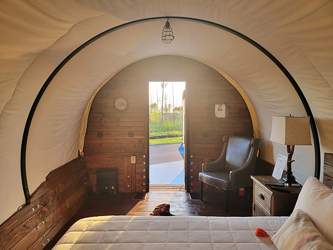 Inside the wagon, rustic wooden walls meet plush bedding, creating a cozy retreat that would make any pioneer jealous.