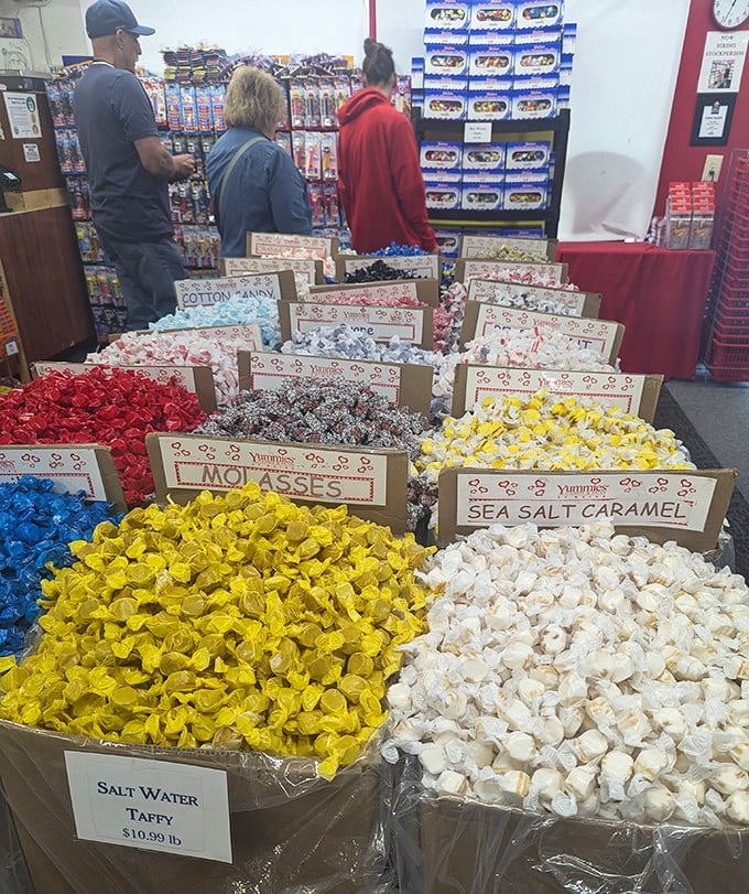 Customers browse the impressive display of colorful taffy varieties, each bin offering a different flavor adventure wrapped in twisted wax paper.