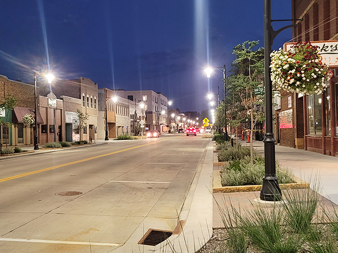 Downtown Owatonna after dark &ndash; where hanging flower baskets and vintage lampposts create small-town magic that big cities try to replicate.