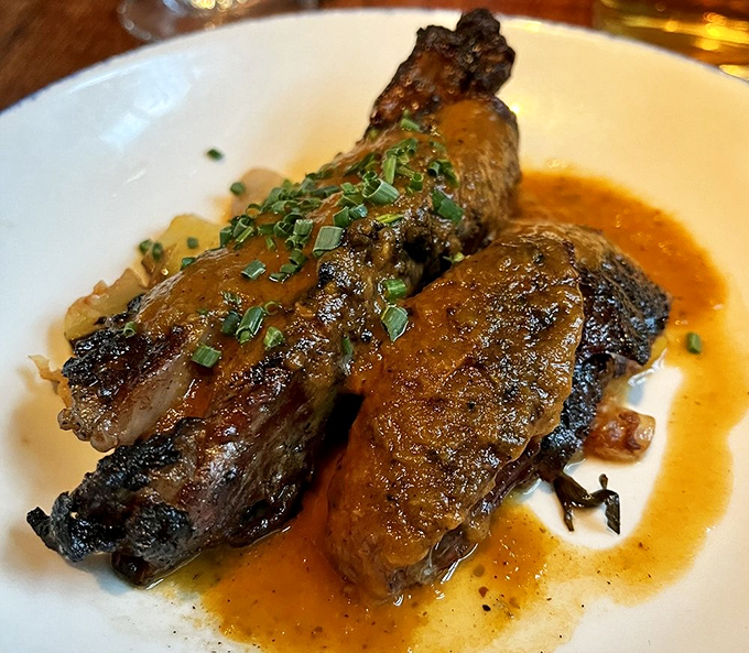 Lamb chops arrive with a golden sear, tender enough to surrender to your fork while vegetables and herbs provide the perfect supporting cast.