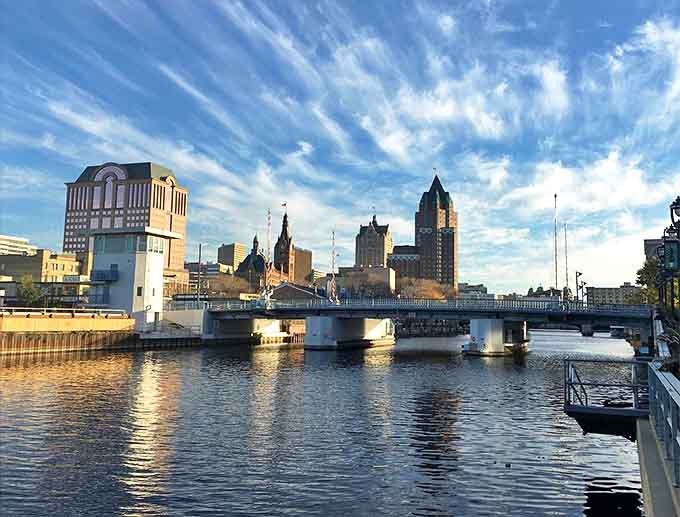 Milwaukee's RiverWalk reflects the city's skyline at golden hour, when urban energy meets Midwestern tranquility along the water.