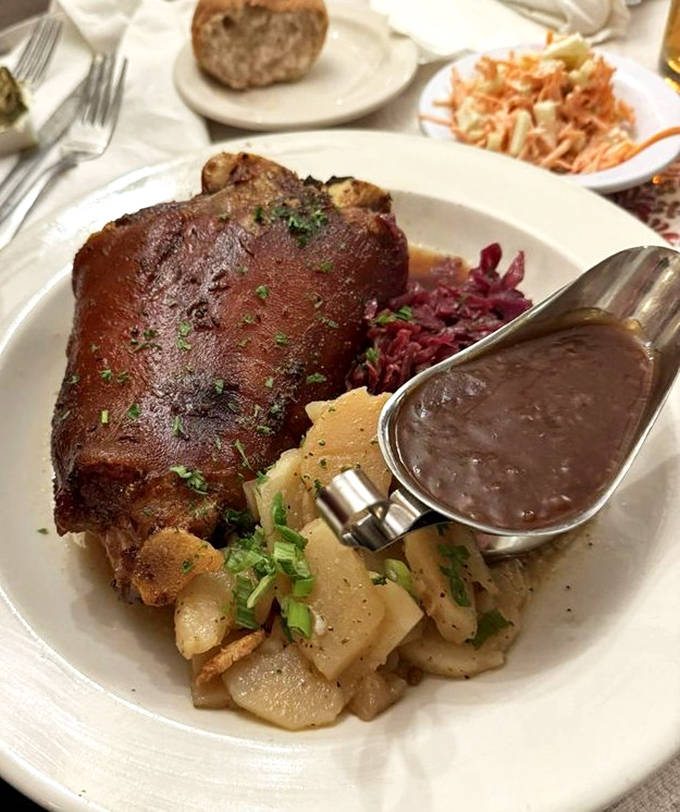 Schweinshaxe (pork knuckle) with all the fixings &ndash; a dish so impressive it deserves its own ZIP code and possibly diplomatic immunity.