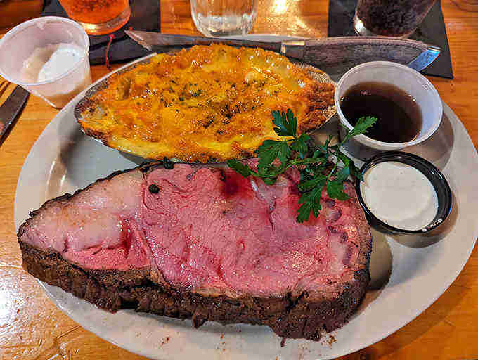 The prime rib arrives in all its glory, perfectly pink and tender, accompanied by a side of potatoes that could steal the show.