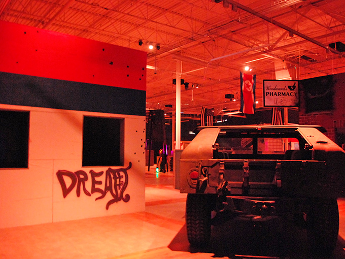 The red-bathed combat zone creates an atmosphere of tension and urgency. Every shadow could conceal an opponent waiting to ambush the unwary.