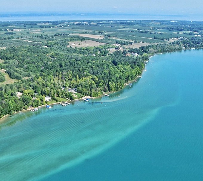 Bird's eye bliss: Elk Lake's turquoise waters carve a stunning contrast against Michigan's lush green landscape.