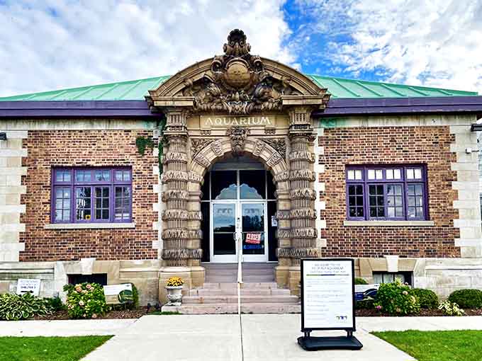 The ornate Beaux Arts entrance, designed by Albert Kahn, features intricate stonework that announces "AQUARIUM" with historic grandeur.