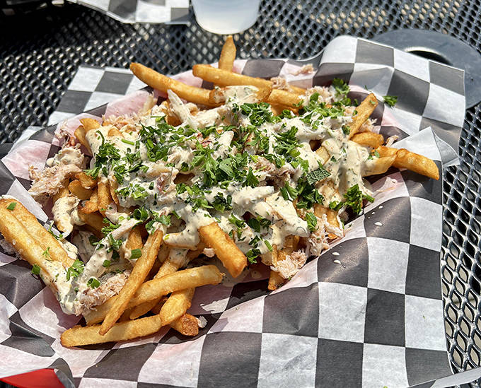 These aren't just any fries, they're a canvas for culinary creativity, topped with tender fish and herbs that elevate the humble potato.