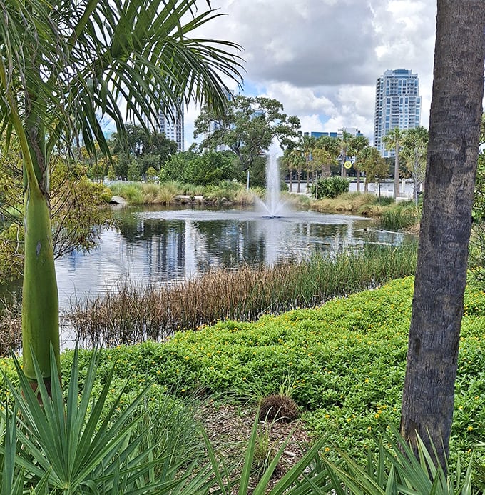 A serene pond with dancing fountain creates a peaceful counterpoint to playground excitement &ndash; nature's own water feature amid lush greenery.