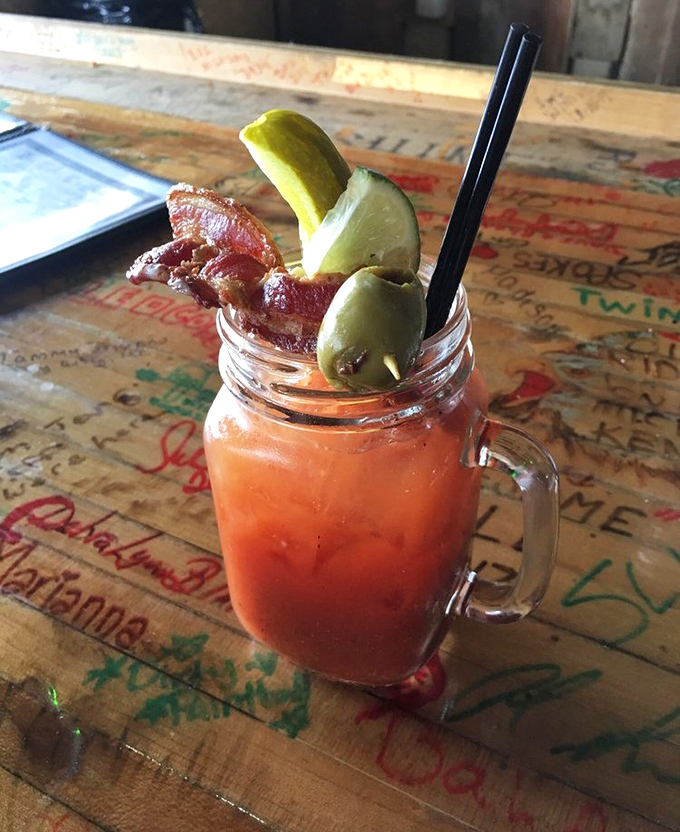 This Bloody Mary isn't just a drink, it's a garden party in a glass, complete with a bacon strip that's living its best life.
