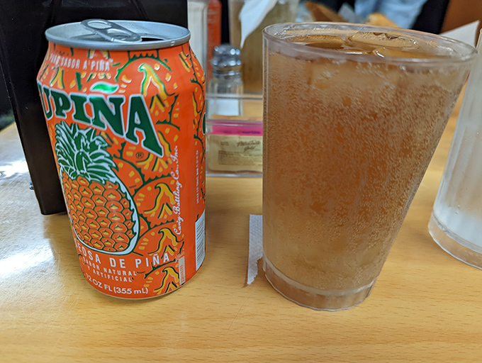 That vibrant orange Jupina soda isn't just refreshment – it's liquid sunshine that perfectly complements your Cuban feast.