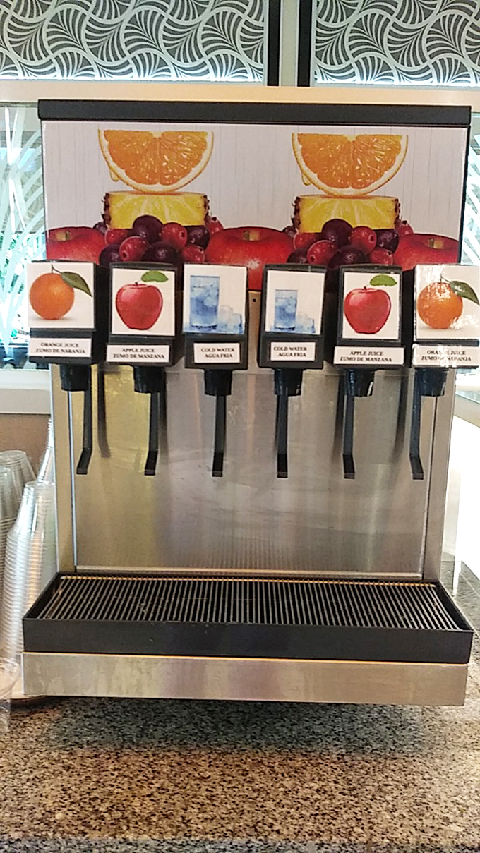 Juice dispensers standing at attention like colorful sentinels, ready to hydrate you between your marathon eating sessions.