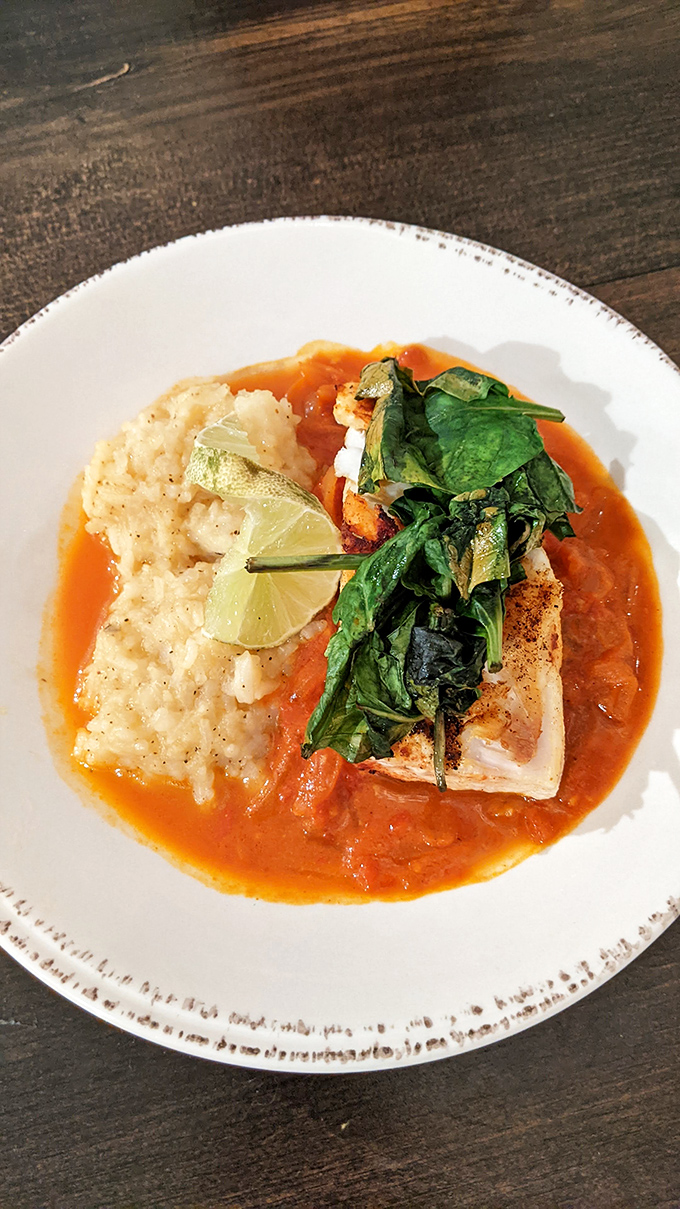 Halibut takes center stage in this beautifully composed plate, where creamy risotto and bright tomato sauce create perfect harmony.