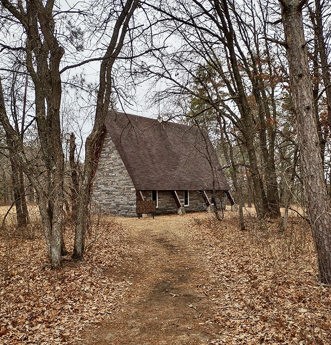 The stone chapel emerges from autumn's fallen leaves, a testament to faith that outlasted the town itself.