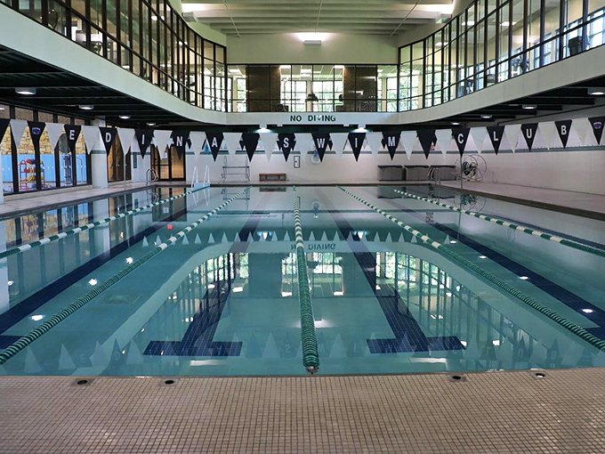 Crystal clear waters beckon swimmers while parents silently calculate how many laps equals one guilt-free donut afterward.