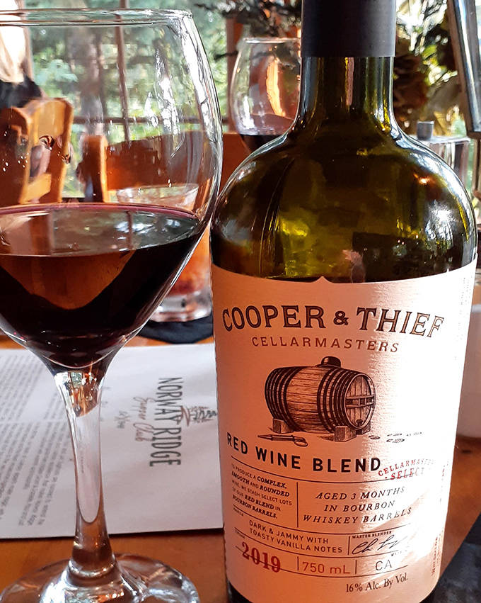 A glass of Cooper & Thief red blend catches the light, promising bold flavors that stand up beautifully to those legendary steaks.