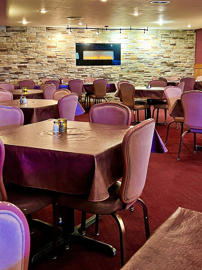 The dining room's stone accent wall and fireplace add rustic elegance that whispers, "Yes, we're casual, but we still care about atmosphere."