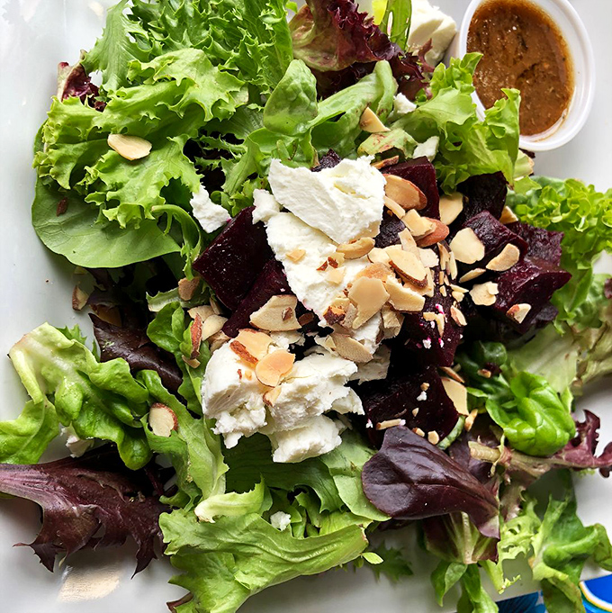 Classic diner aesthetics &ndash; where greens meet plates and every surface tells stories of meals shared over decades.