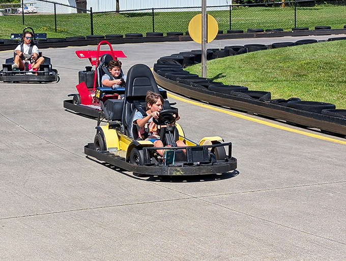 People racing go-karts: The look of determination as young drivers grip steering wheels, tongues slightly out in concentration, racing toward family bragging rights.