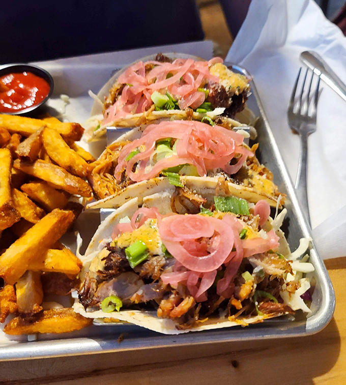 These pulled pork tacos tell a story with each bite &ndash; tender braised meat, crunchy slaw, and pickled red onions creating perfect textural harmony.